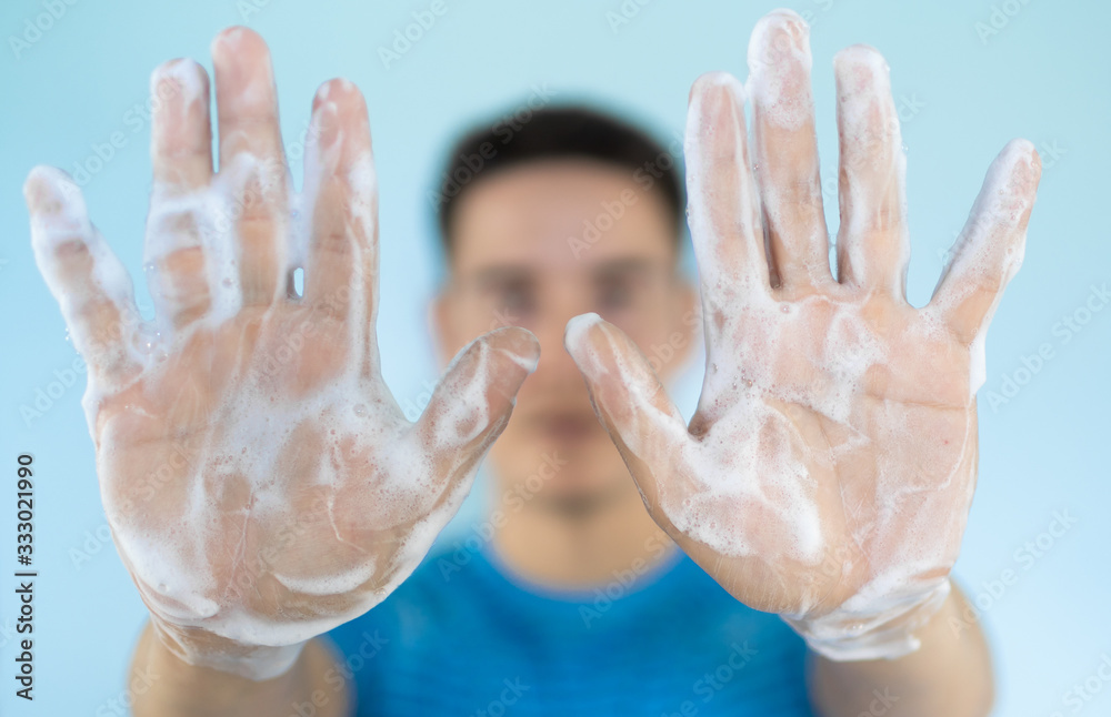 Wash your hands with soap and water. Young man holding up soapy hands ...