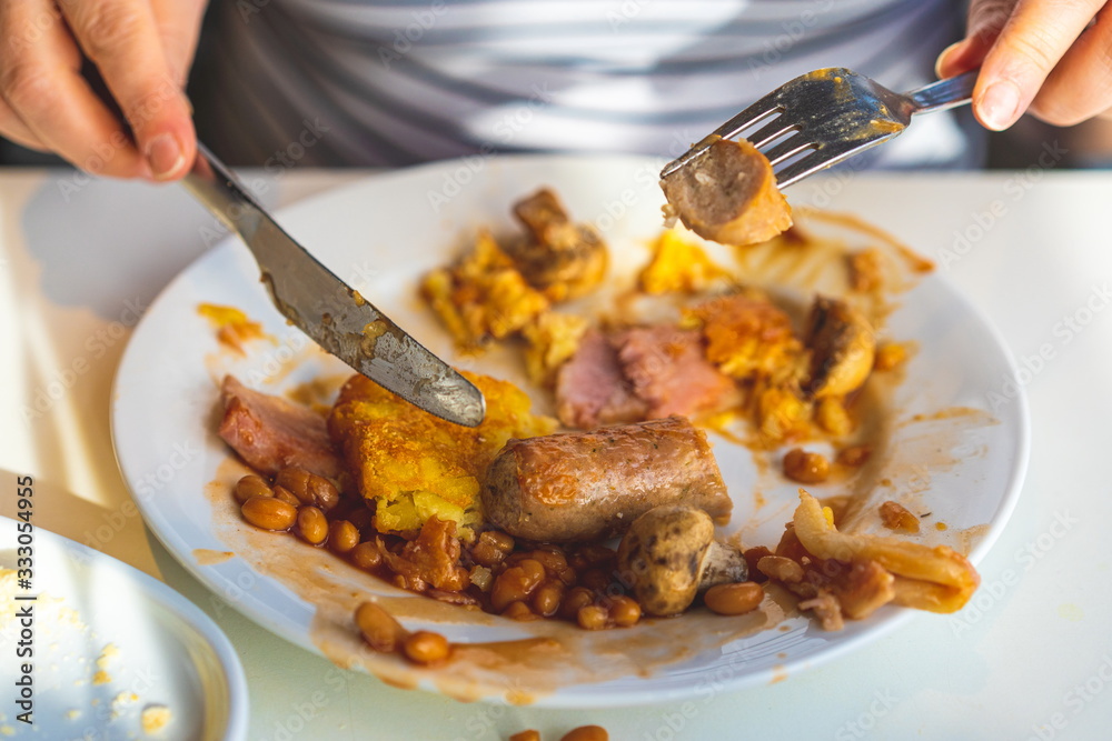 Woman eating traditional full English breakfast at the restaurant. Full ...