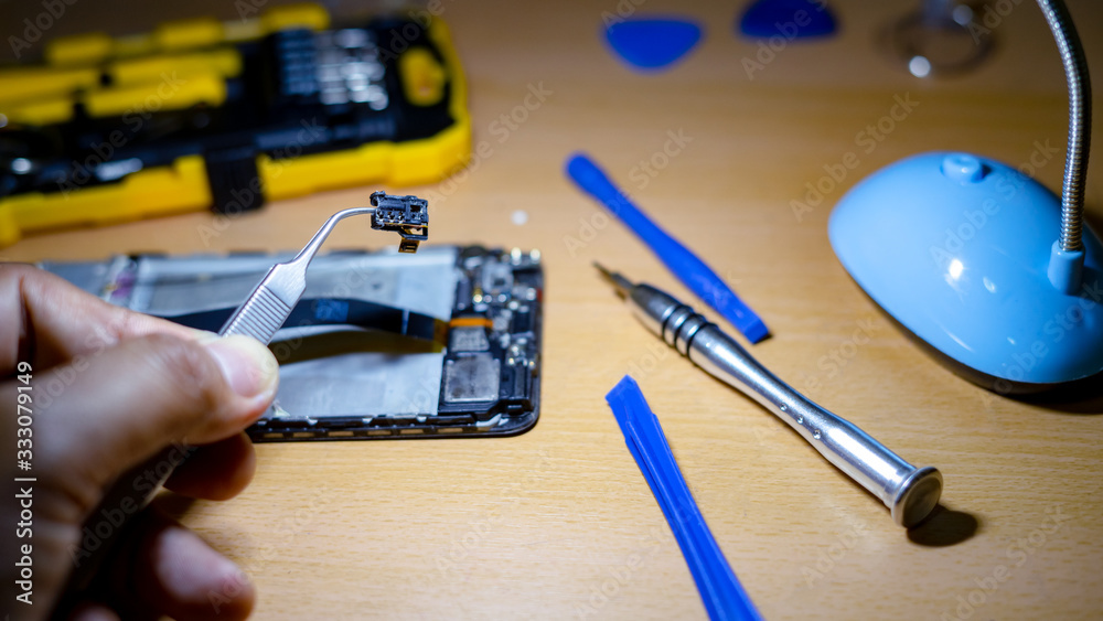 Repairing the chip of smartphone motherboard in the lab. Cell phone ...