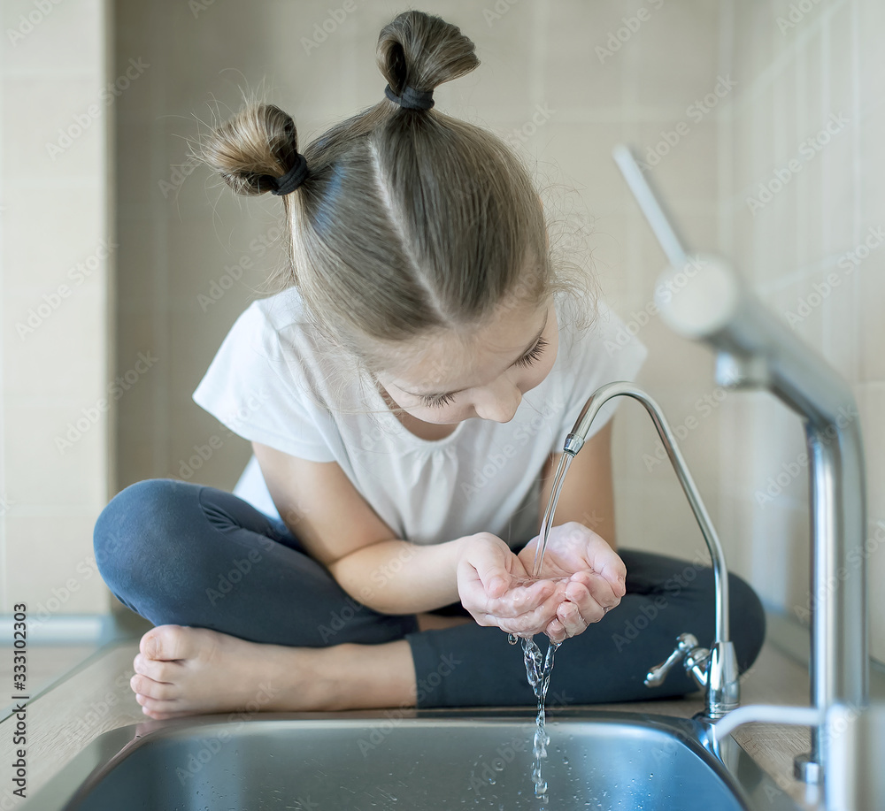 Healthy thirsty caucasian child drinking from water tap or faucet in ...