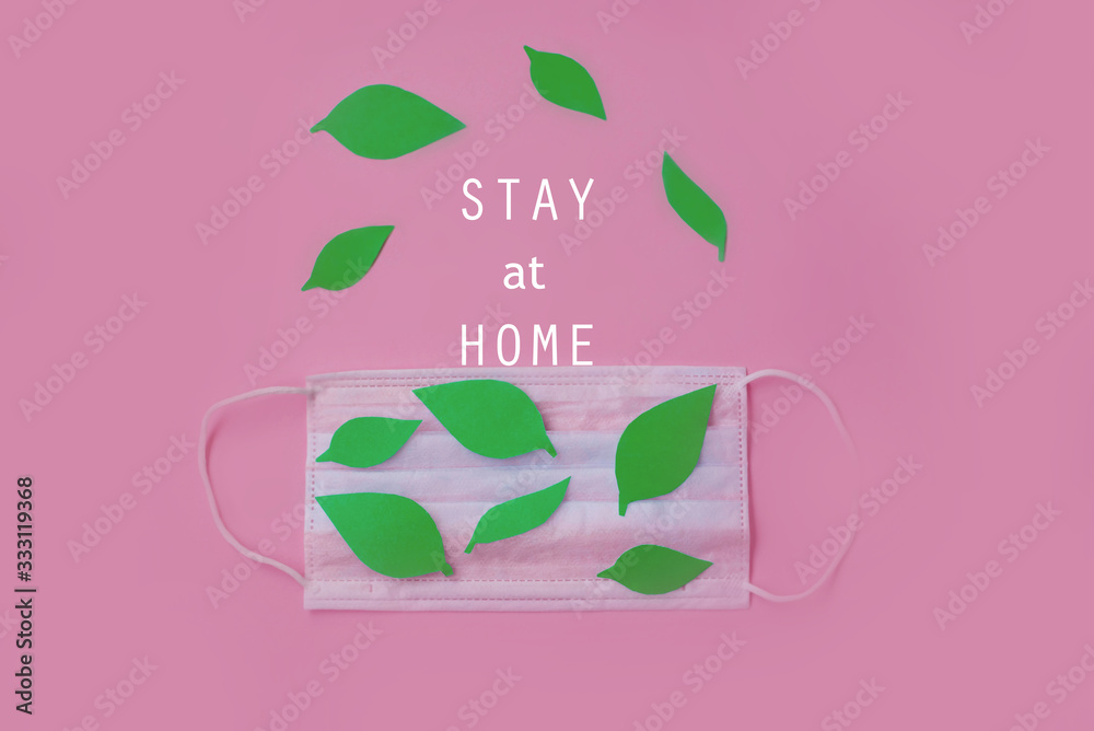 Medical mask, green paper leaves. Virus and spring. Stay at home ...