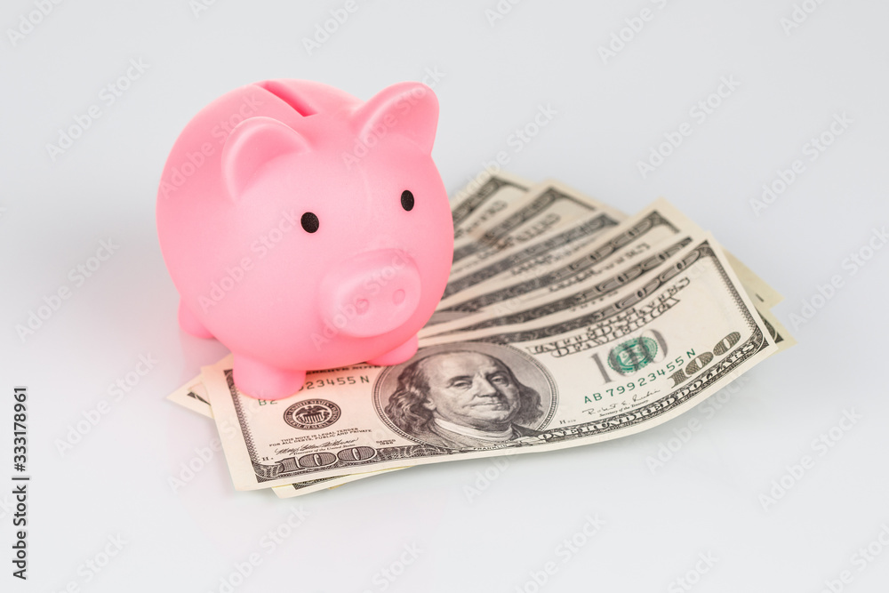 Pink piggy money box in pile of dollar banknotes, currency concept ...