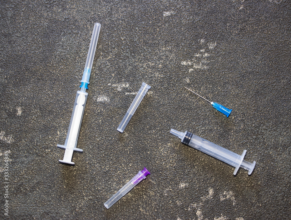 Coronavirus and flu remedy. Medical syringes on a black background ...