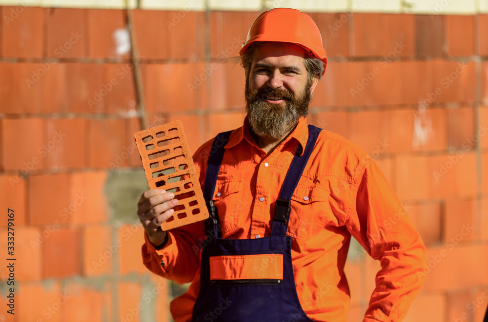 Element in masonry construction. Builder hold brick. Bearded man wear ...
