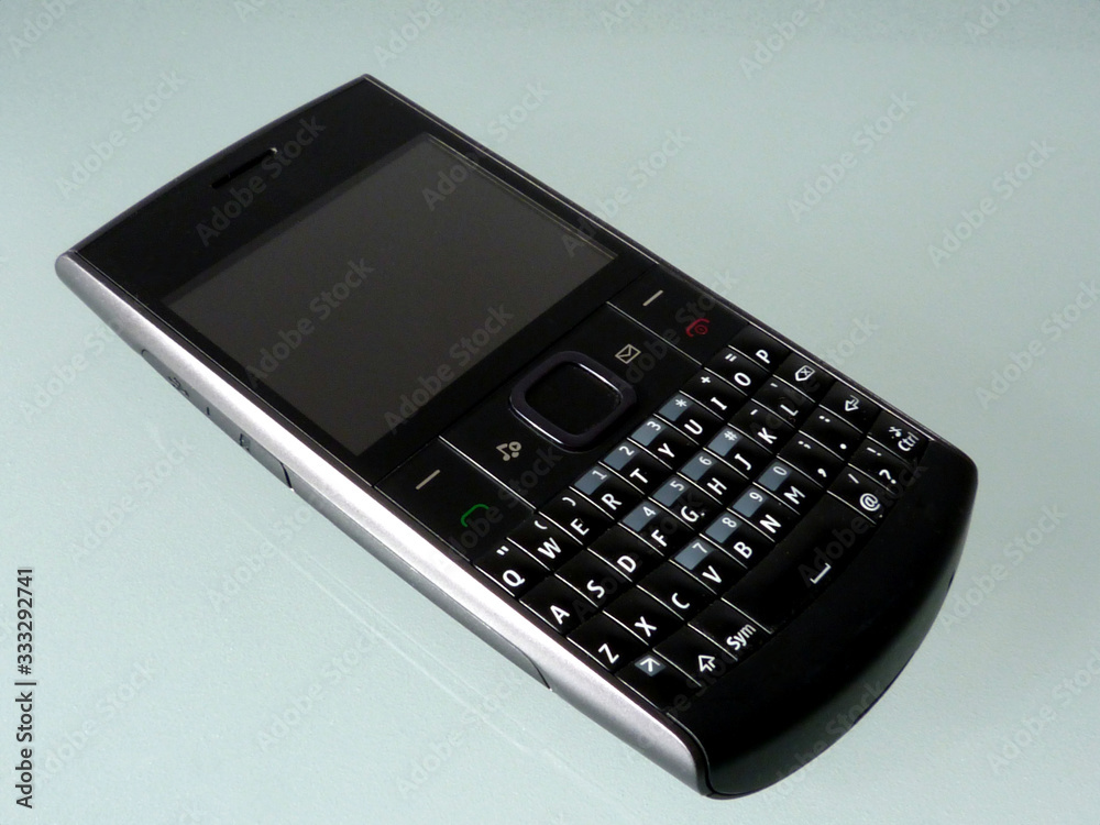 isolated vintage black cell phone. button style keypad. mobile close up ...