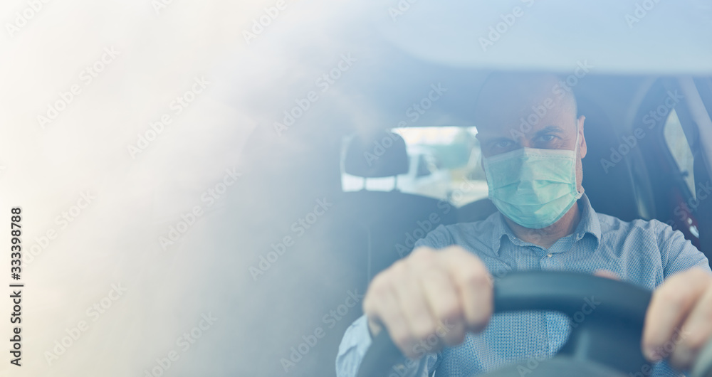 Driving a driver with a face mask while driving Stock Photo | Adobe Stock