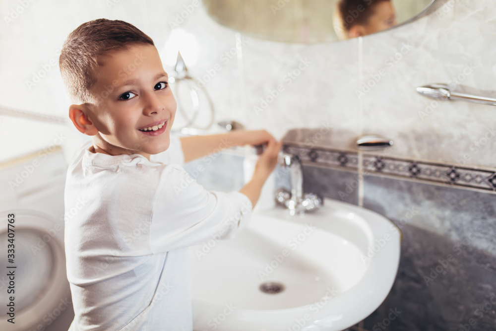 Cute boy washing his hands in bathroom. Protection against viruses and ...