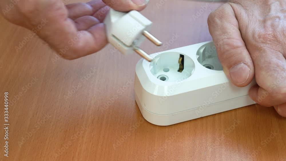 Connect and disconnect the power cable. A male hand connects an ...