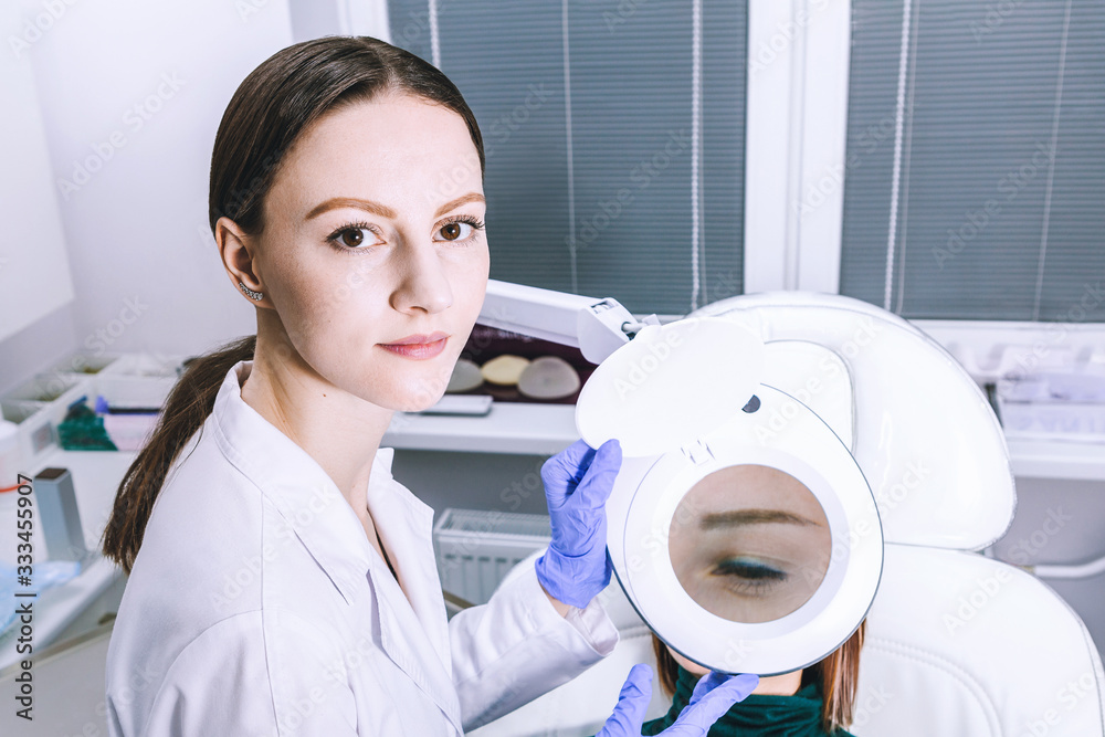 Female woman doctor is analyzing skin through magnifier on female ...