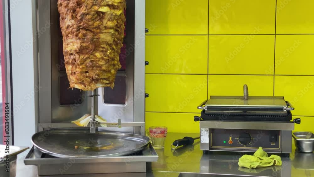 Skewered roasted chicken shawarma meat cooking and turning on rotating ...