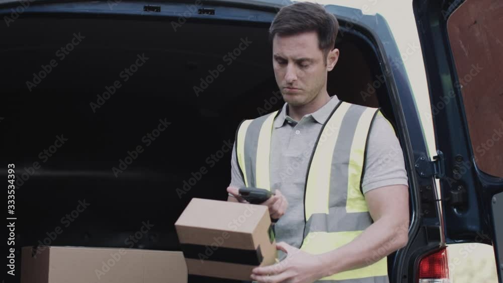 Delivery man scanning boxes with barcode scanner Stock Video | Adobe Stock