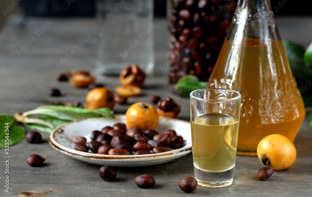 Liqueur nespolino. Loquat seed liquor. tincture alcoholic on bones ...