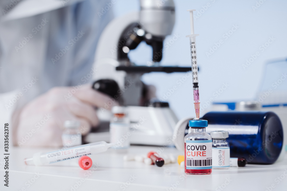 Microbiologist examines the sample under a microscope. Coronavirus ...