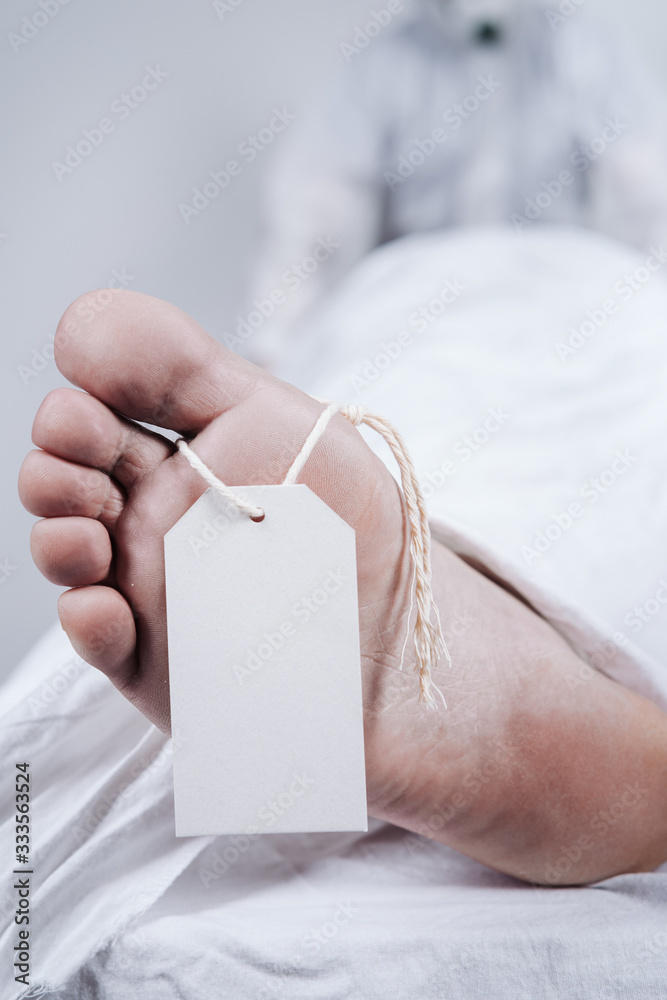 Feet of a dead body, with an identification tag - blank sign attached ...