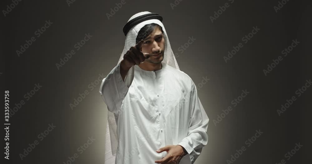 Arabian man looking at camera and positively smiling, pointing at ...