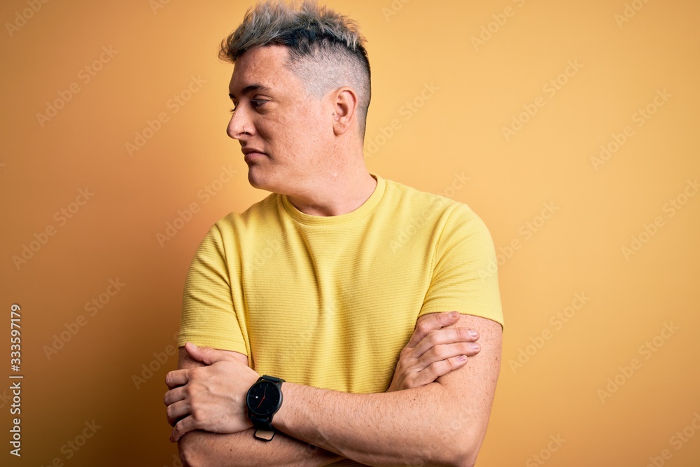 Young handsome modern man wearing yellow shirt over yellow isolated ...
