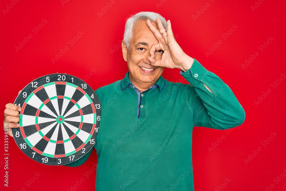 Middle age senior grey-haired man holding competition dartboard target ...