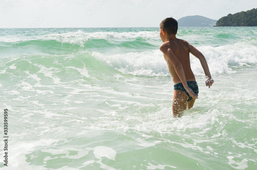 Child caucasian boy rear view dives into the sea . Active holidays in ...