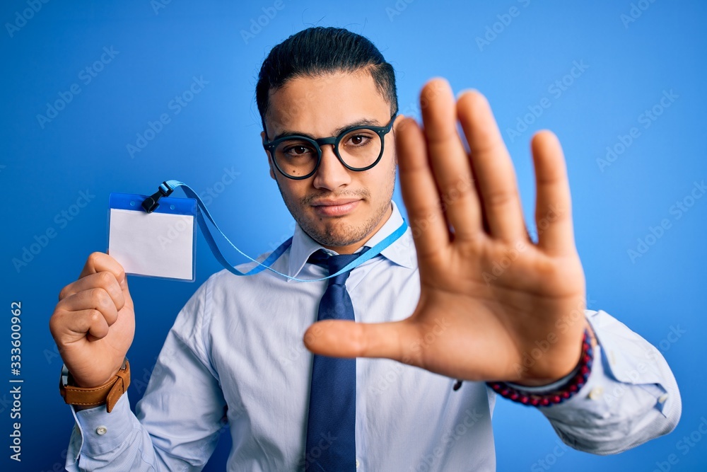 Young brazilian call center agent man holding id identification card ...