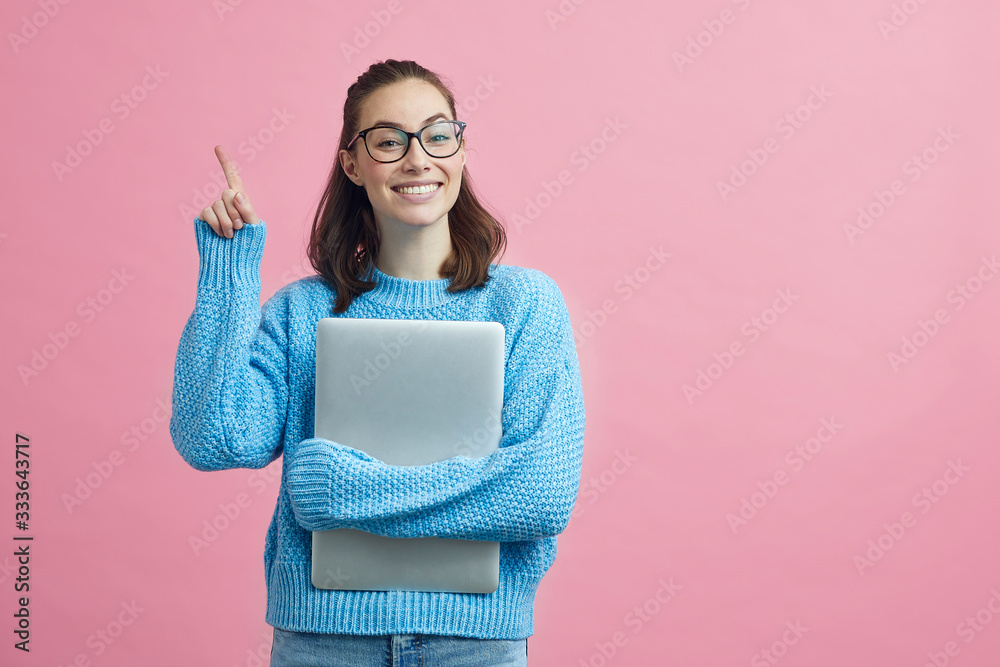 Smart looking student on colorful background holding her finger up to ...