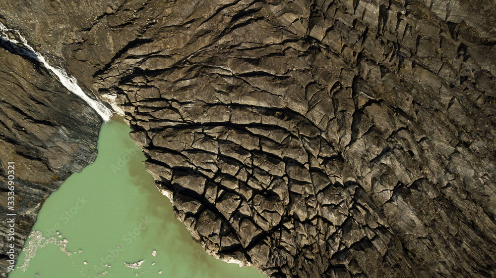 Aerial top view on Black Glaciar covered with volcanic black ash. Black ...