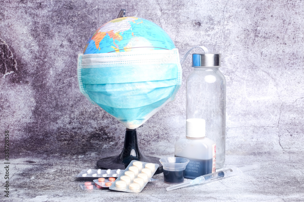 Foto de Globe wearing mask with medicines, injection syringe an glass ...
