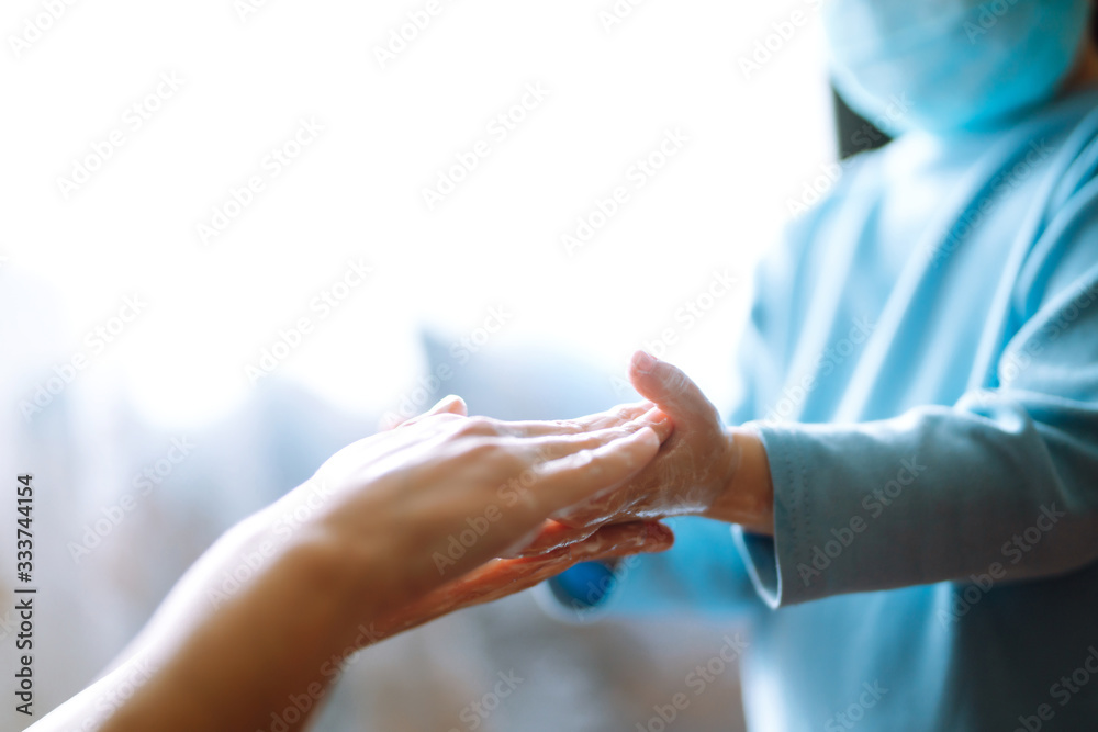 Mom helps her chaild wash her hands. They are rubbing their hands ...