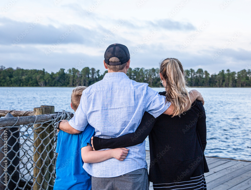 Foto de Rear view of parents with child standing together on the ...