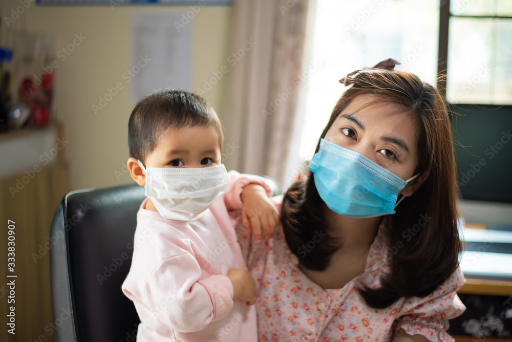 mother and her daughter wearing surgical mask stay at home. Covid-19 ...