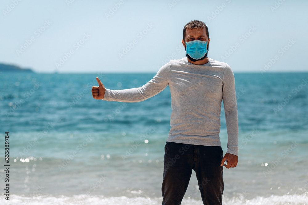 COVID-19 Pandemic Coronavirus safe traveler on the beach wearing face ...