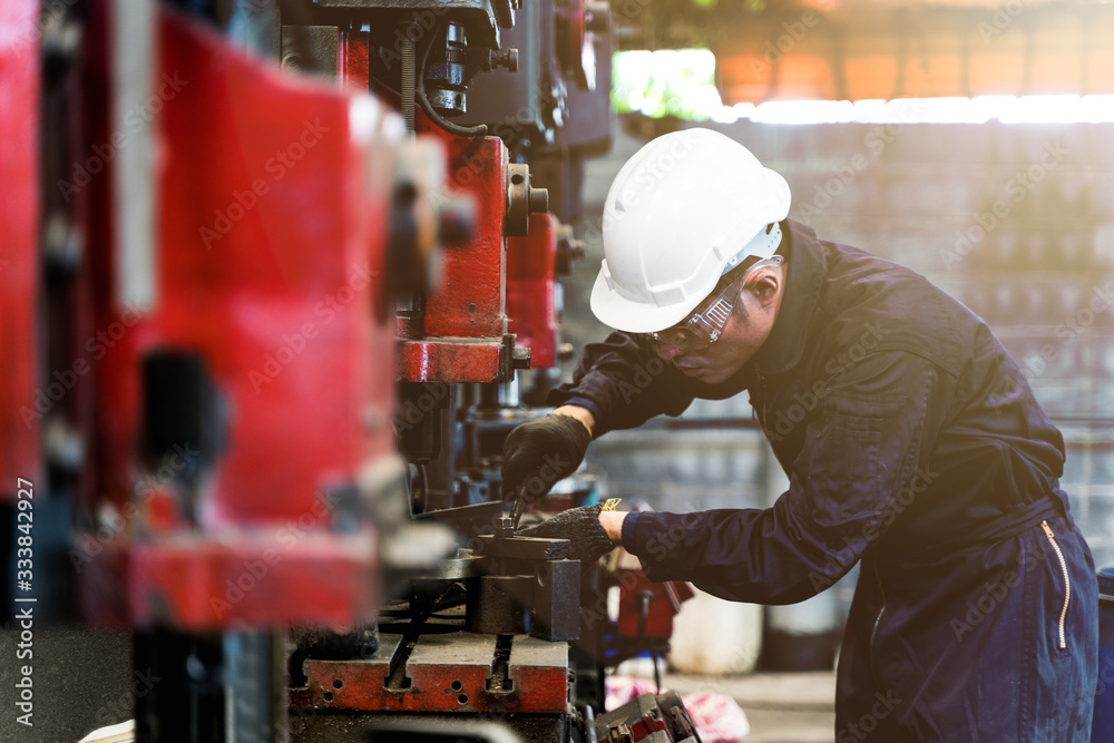 Professional asian worker stand and maintenance the big machine in the ...