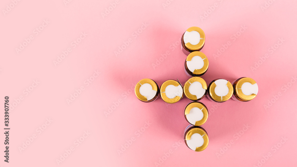 Sign of the cross on a pink background made of medical jars of drugs ...
