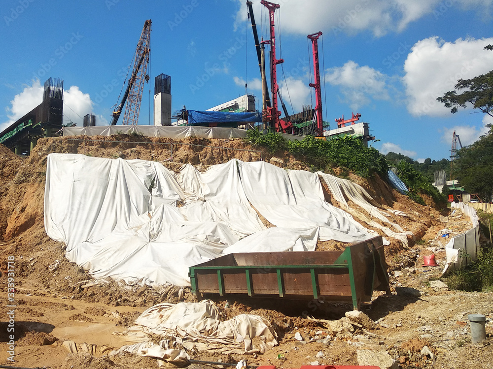 The geotextile fabric is spread over the surface of the slope to ...