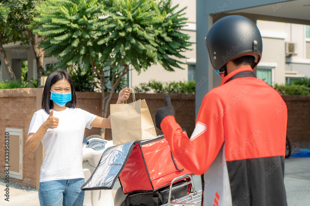 Asian woman pick up delivery food bag from box and thumb up form ...