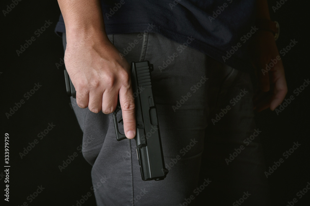 Foto de Man holding gun close to the body, Killer with 9mm handgun ...