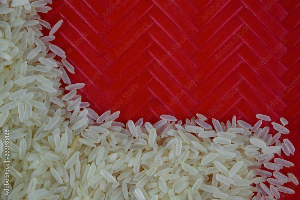 Grains of rice held in a designed red carpet where the rice grains are ...