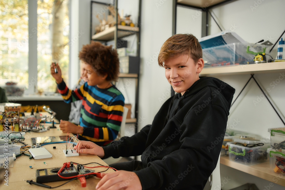 Education is power. Caucasian boy looking at camera while making toys ...