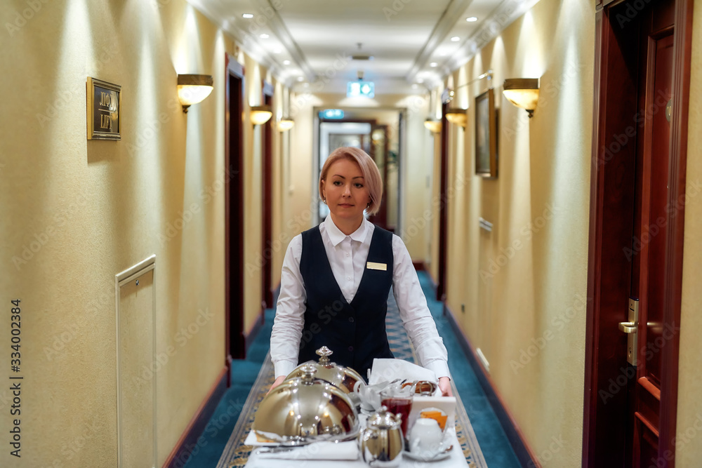 Experience the passion of hospitality. Waitress in uniform walking ...