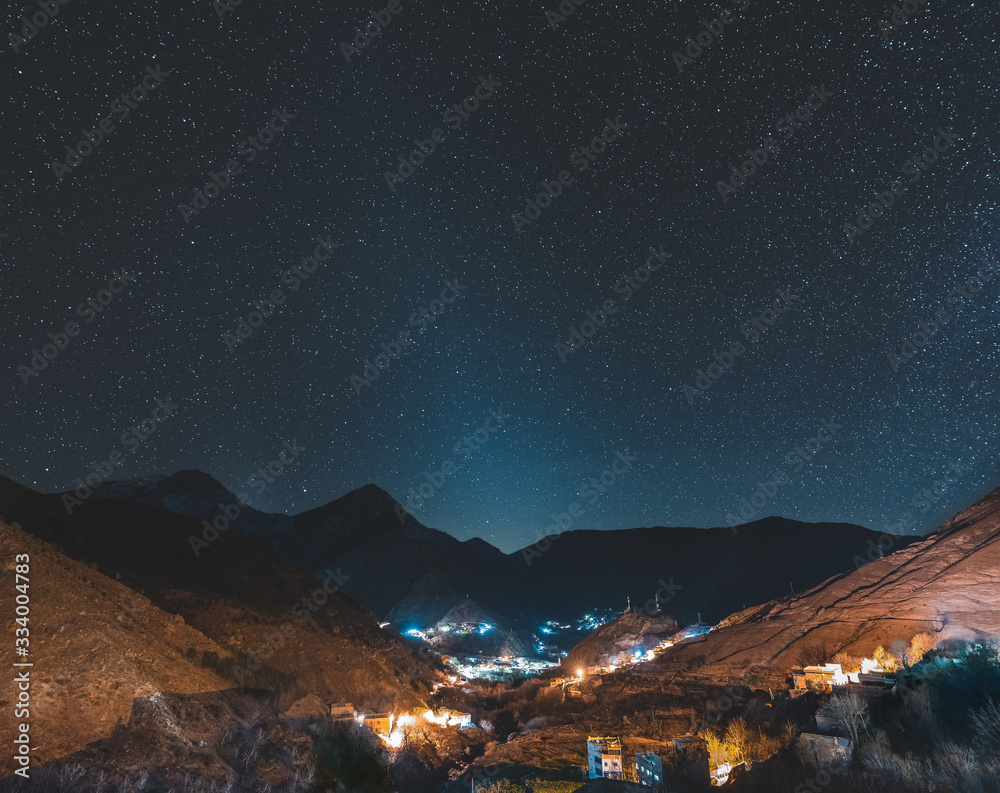 Night sky scene with the Milky Way and stars above Imlil. Small village ...