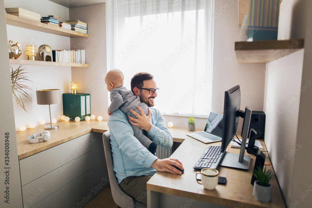Young father working from home and babysitting. Stock Photo | Adobe Stock