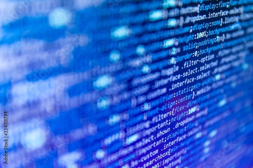 HTML CSS3 source code on lcd screen with black background. Developer working on program codes in ...