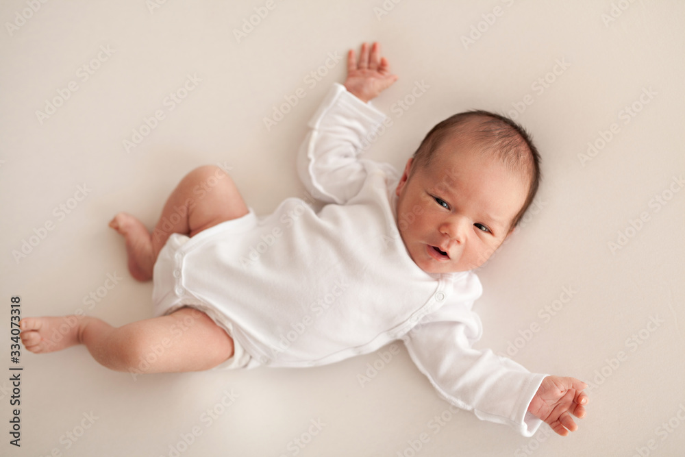 Newborn baby boy in white body on bed Stock Photo | Adobe Stock
