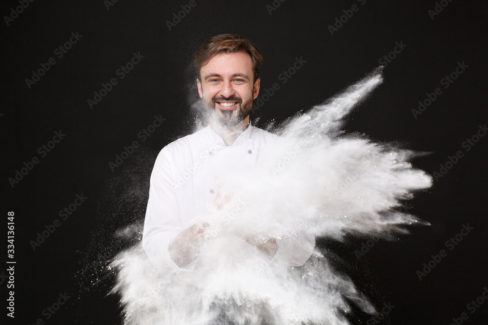 Smiling young bearded male chef cook or baker man in white uniform ...