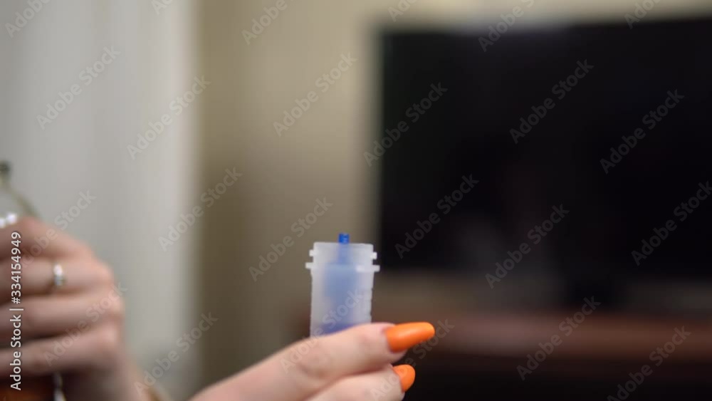 woman sets up a nebulizer prepare makes inhalations with a nebulizer at ...