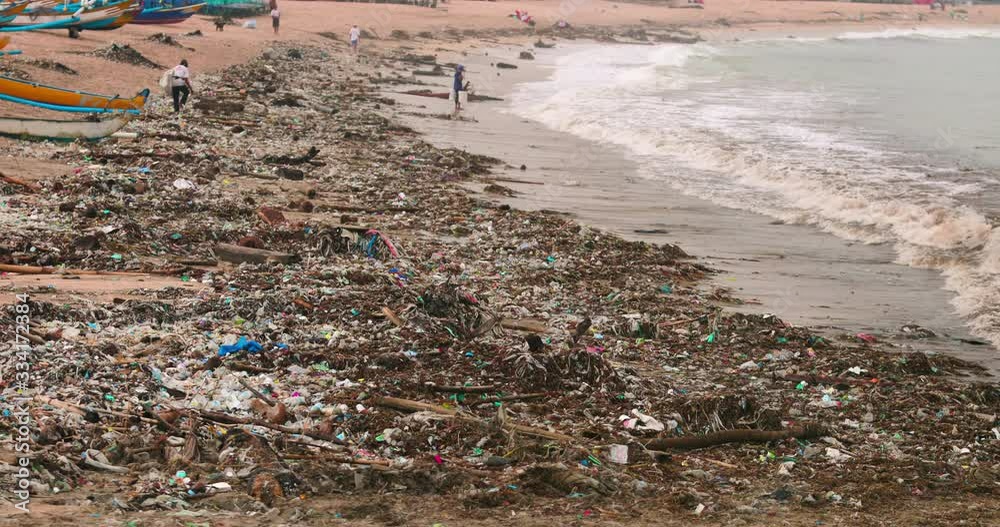 Man is walking along the worlds most polluted beach in Bali. Plastic ...