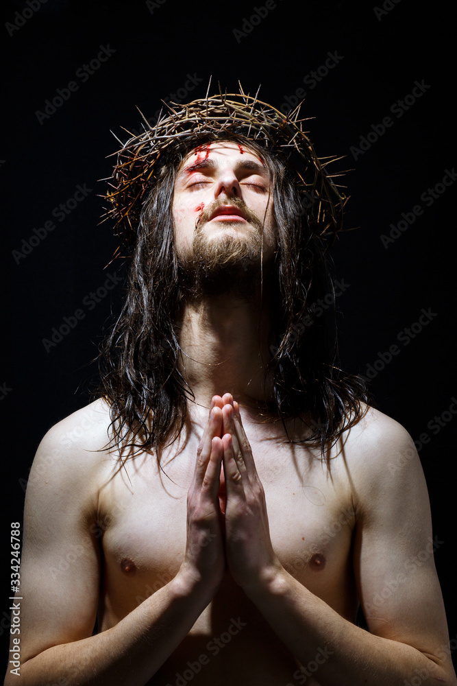 Jesus Christ of Nazareth with crown of thorns prays with raised head ...