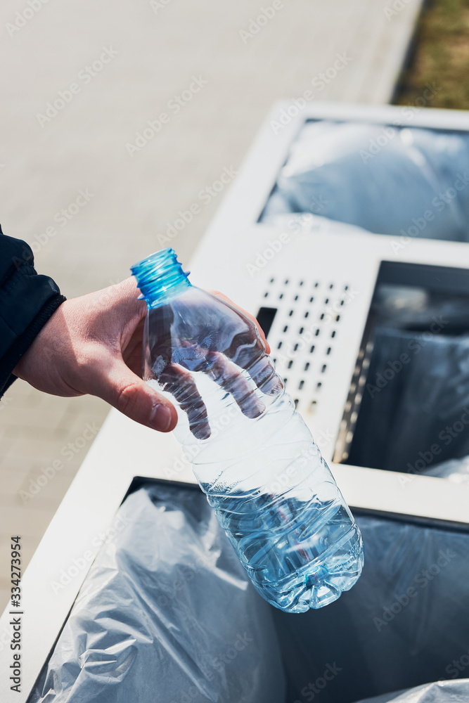 Man throwing a plastic bottle to trash. Plastic waste to recycling ...