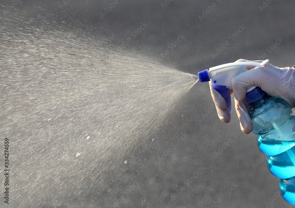 Human hand in glove spraying antibacterial or cleaning solution from ...