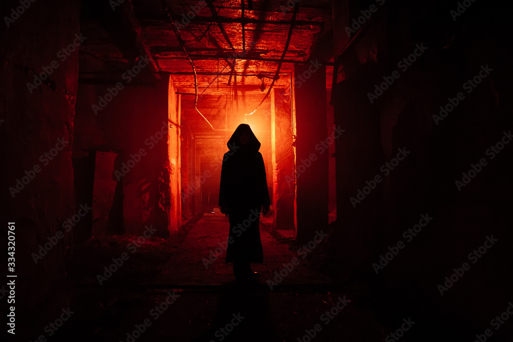 Creepy silhouette in the dark red illuminated abandoned building ...