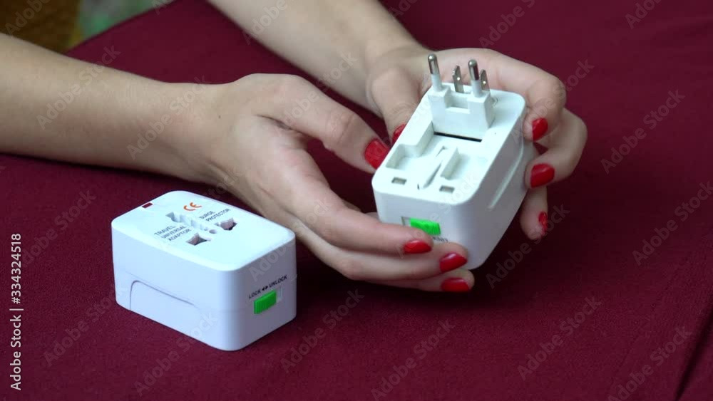 Beautiful hands of girl showing how to use universal electric socket ...